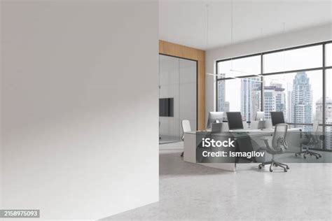 목재 요소 천장부터 바닥까지 내려오는 대형 창문 책상과 의자 가벼운 디자인 스타일 도시 스카이라인이 내려다보이는 넓고 현대적인