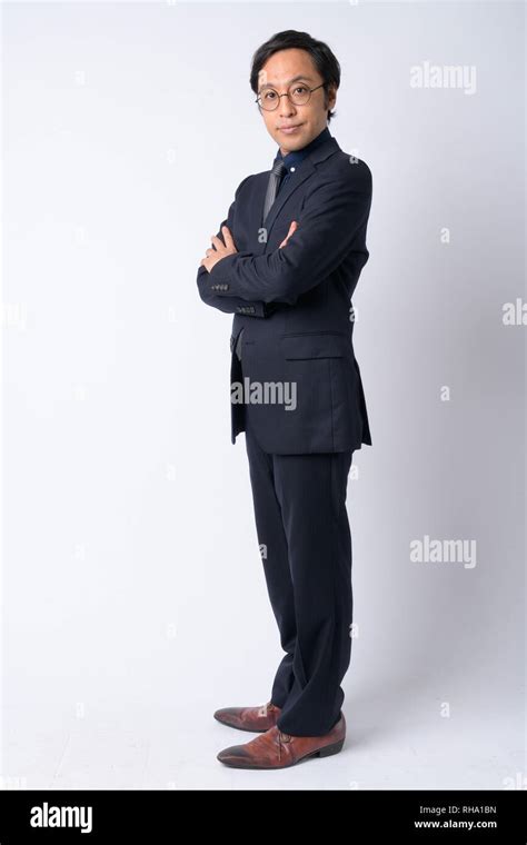 Full Body Shot Profile View Of Japanese Businessman In Suit With Arms