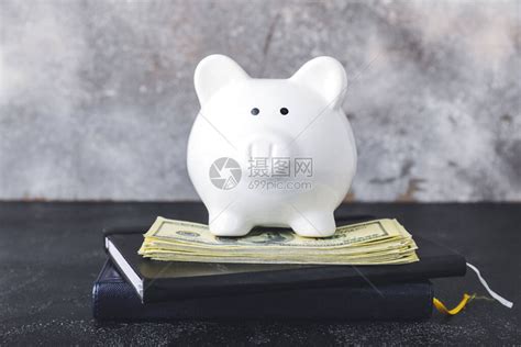 存钱罐笔记本和桌上的钱债务的概念高清图片下载 正版图片503987042 摄图网