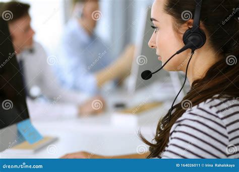 Business Woman Using Headset For Communication And Consulting People At