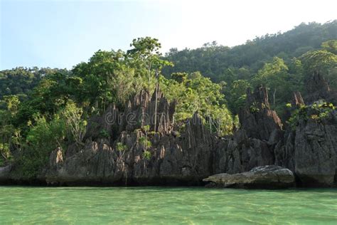 Island Cliff And Ridge Forming Structure With Green Sea Water Stock