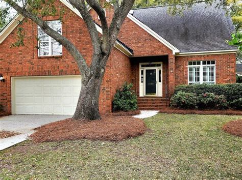 Red Brick House With Tree In Front Yard