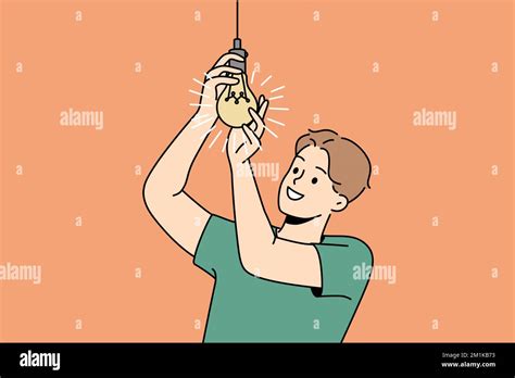 Smiling Young Man Screwing Lightbulb At Home Happy Guy Connect Light