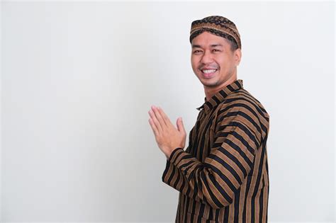 Premium Photo Side View Of Javanese Man Smiling At Camera While Doing Greeting Pose