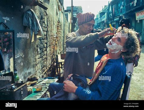 India Varanasi Benares Tourist Gets Shaved By A Street Barber Stock