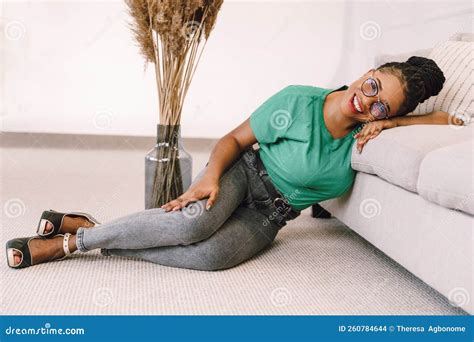 Beautiful Young Black Woman Laying On Sofa And Sitting On The Floor