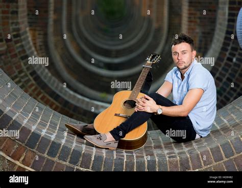 Singer Songwriter Jamie Mathias Poses With His Guitar For A Shoot At