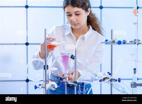 Young Adult Female Scientist Conducts A Chemical Experiment In A