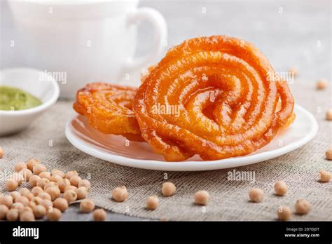 Traditional Indian Candy Jalebi In White Plate With Mint Chutney On A