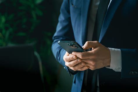 손에 휴대 전화를 가진 정장을 입은 사업가 소셜 넷을 사용하여 메시지를 입력하는 남자 뉴스 확인 비즈니스 미팅 만들기 현대적인 사무실 일반 관리자 Ceo 파트너에게 전화하기