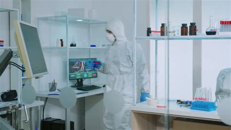 Team Of Scientists In Ppe Suit Analysing Test Trial Vaccine In Lab