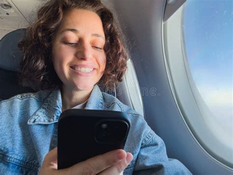 Passenger Woman Is Flying In Plane Girl Using Phone Sitting By