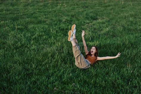 A Young Woman Playing Games In The Park On The Green Grass Spreading