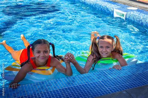 Two Tween Girls Playing Splashing Laughing And Have Fun In The Blue