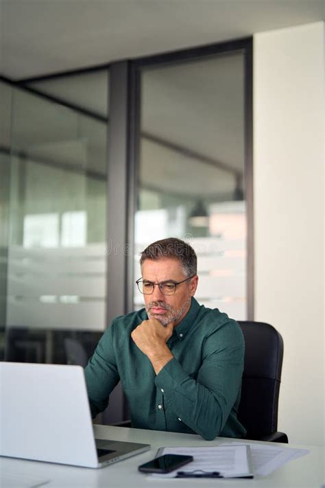 Older Professional Business Man Looking At Laptop Working In Office