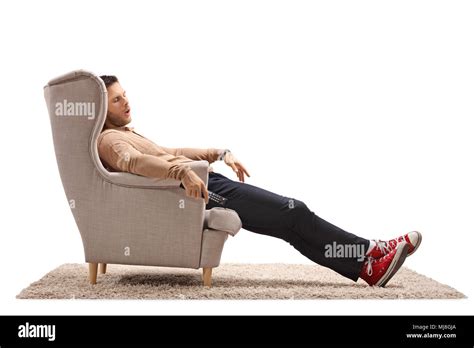 Young Man With A Remote Control Sleeping In An Armchair Isolated On