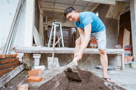 Premium Photo Asian Man Doing Construction Work Is Mixing Cement With Sand Using A Hoe For The