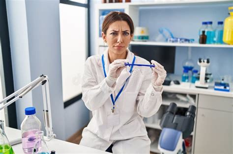 Young Brunette Woman Working At Scientist Laboratory Wearing Safety