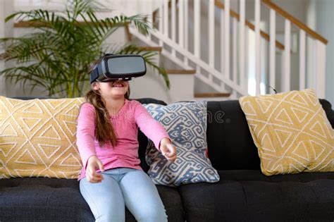 Girl Sitting On Dark Grey Couch Wearing Vr Headset In Modern Living