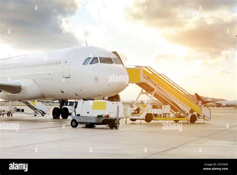 Front View Of Large White Passenger Airplane And Air Stairs To The Door
