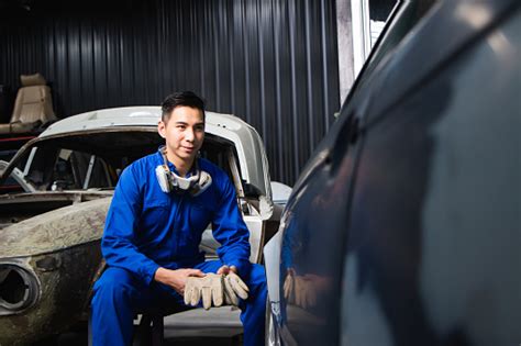 기업가 사업가 중소기업 소유자 차고 자동차 수리점 화가 점프 수트와 먼지 마스크를 착용 차고에 앉아 휴대 전화와 노트북을