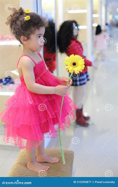 Little Barefoot Girl With Flower Stands On Pouf In Stock Image Image