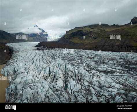 Surface Of Melting Glacier Tongue Black And White Ice With Volcanic Ash Layers And Turquoise