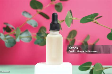 분홍색 배경에 유칼립투스 가지와 연단에 유리 드롭퍼 병 화장품 용기 모형 브랜딩 및 패키징 프레젠테이션을 위한 배경 내츄럴 스킨케어 뷰티 제품 컨셉 0명에 대한 스톡 사진