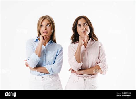Image Of Thinking Attractive Two Women Looking Upward While Posing At