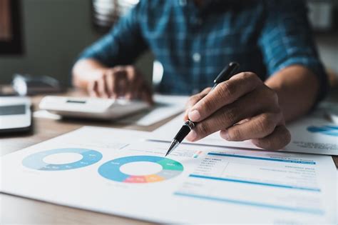 비즈니스 재무 및 회계 개념을 사용하여 새로운 시작 프로젝트 토론 및 분석 데이터 차트 및 그래프 계산기 랩톱 컴퓨터로 작업하는 사업가 프리미엄 사진