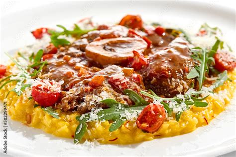 Traditional Italian Dish Osso Buco With Risotto Milanese And Cherry