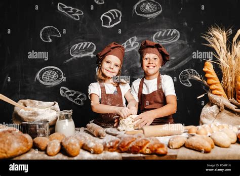 Adorable Girl With Brother In Aprons On Table With Bread Loaves Making