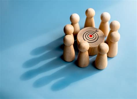 Das Zielsymbol Auf Einem Runden Holzblock Umgeben Von Kleinen Menschlichen Holzfiguren Bildete