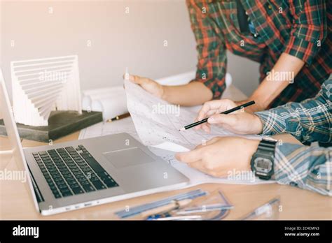 Two Engineering Man Working At Office Room And Discussing Together With Looking At Blueprint
