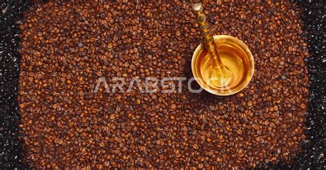 صورة مقربة لحبوب البن الداكنة مع مطحنة نحاسية قديمة، حبوب البن المتناثرة، مطحنة يدوية، بذور البن