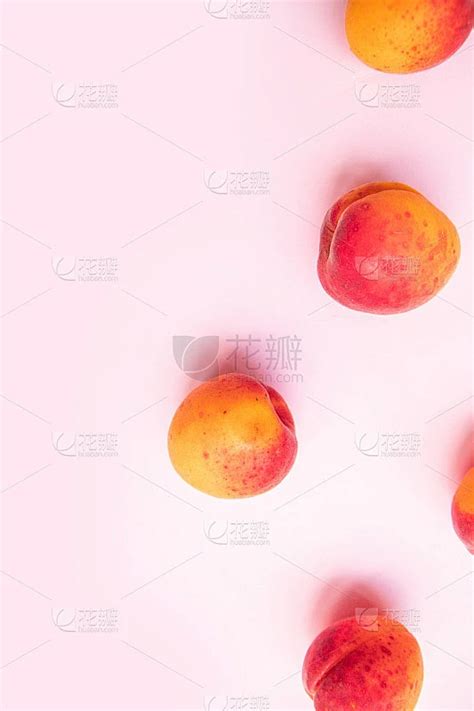 以粉红色为背景的甜水蜜桃的平面构图。夏天新鲜的果子。素材 花瓣网