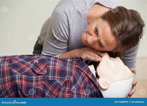 Woman In First Aid Class Checking Airway On Cpr Dummy Stock Image