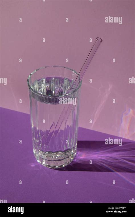 Reusable Glass Straws In Glass With Water On Purple Violet Background