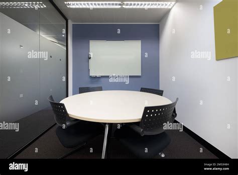 Small Boardroom With White Round Circular Table And Whiteboard With