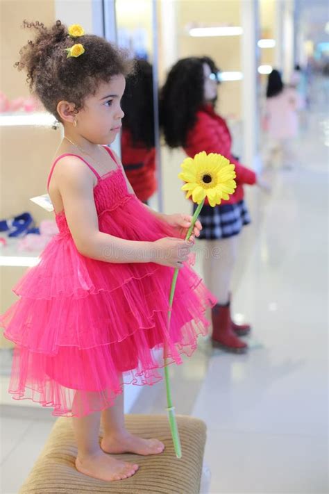 Little Barefoot Girl With Flower Stands On Pouf In Stock Image Image