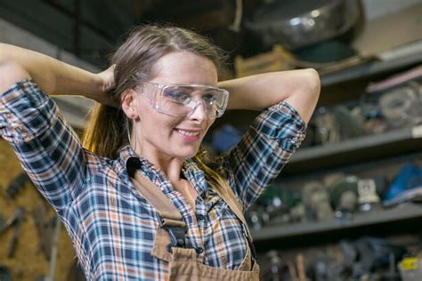 Premium Photo Close Up Of Smiling Woman Tying Hair In Workshop