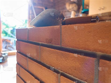 炉子泥铲被留在一个未完工的砖炉上。