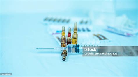 복사 공간이있는 파란색 배경의 의료 병 바이알 주사기 및 얼굴 마스크 예방 접종 세션 및 면역 개선 예방 접종 개념 의료 병원 및 의료 진단 간호사에 대한 스톡 사진 및