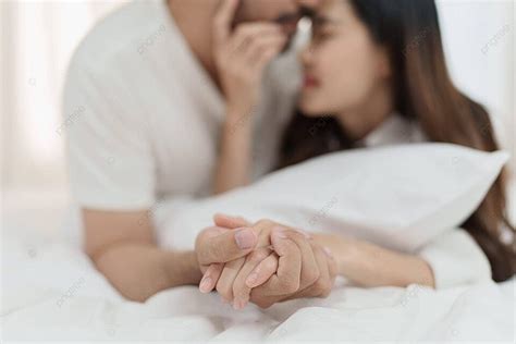 زوجان آسيويان جميلان يتمتعان بالمداعبة الحسية في السرير صورة الخلفية