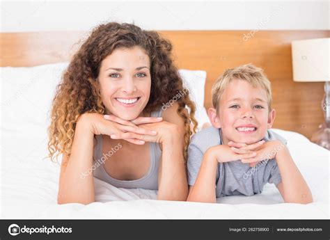 Cheerful Mother Son Lying Bed Looking Camera Home Bedroom Stock Photo By YAYImages