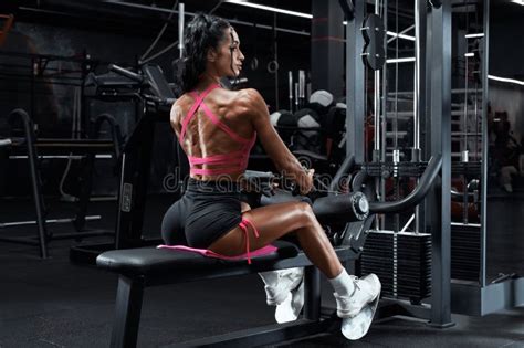 Fitness Woman Working Out In Gym Doing Exercise For Back Athletic Girl Doing Cable Row Stock