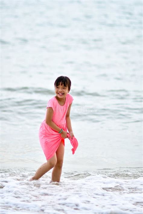 Asian Girl With Pink Dress Playing By The Seaside Stock Image Image