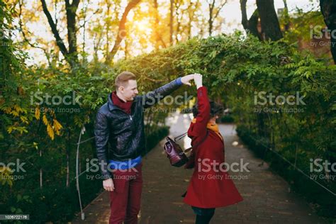 사랑 매력적인 여자와 남자 캐주얼 따뜻한 옷 춤과을 도시 공원 야외에서 녹색 아치 근처 산책 소용돌이에 젊은 아름 다운 커플 사랑 관계 가족 라이프 스타일 개념입니다 가을에