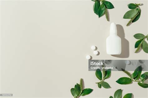 계절 알레르기 개념 새로운 녹색 잎과 캣킨이 있는 봄 어린 가지 나무 흰색 비강 스프레이 베이지색 배경에 의료용 알약 최소한의 창의적인 탑 뷰 트렌드 플랫 레이 사진