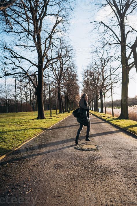 Portrait Of A Brunette Girl Having Fun In A Park In The Rays Of The